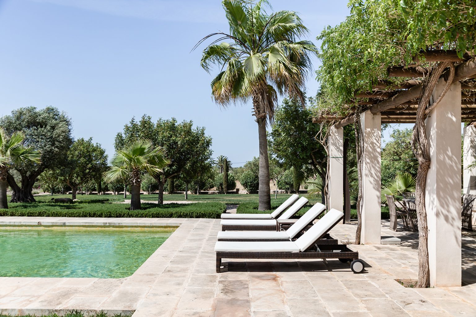 Lush gardens wrap around this rustic Mallorcan Finca in Santayi