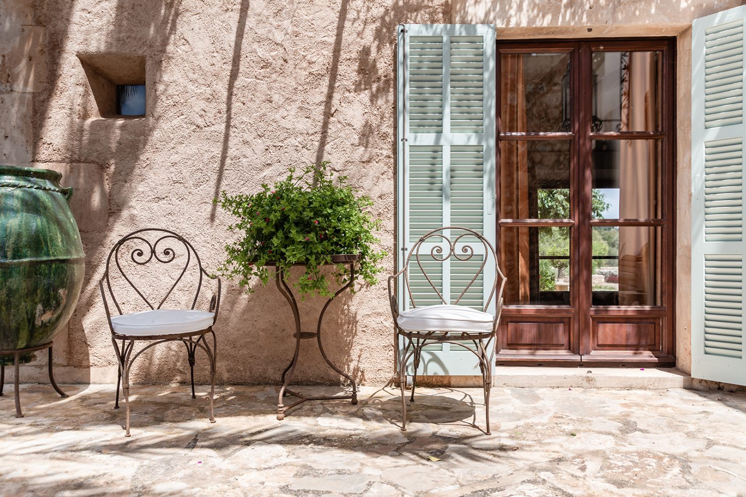 Lush gardens wrap around this rustic Mallorcan Finca in Santayi