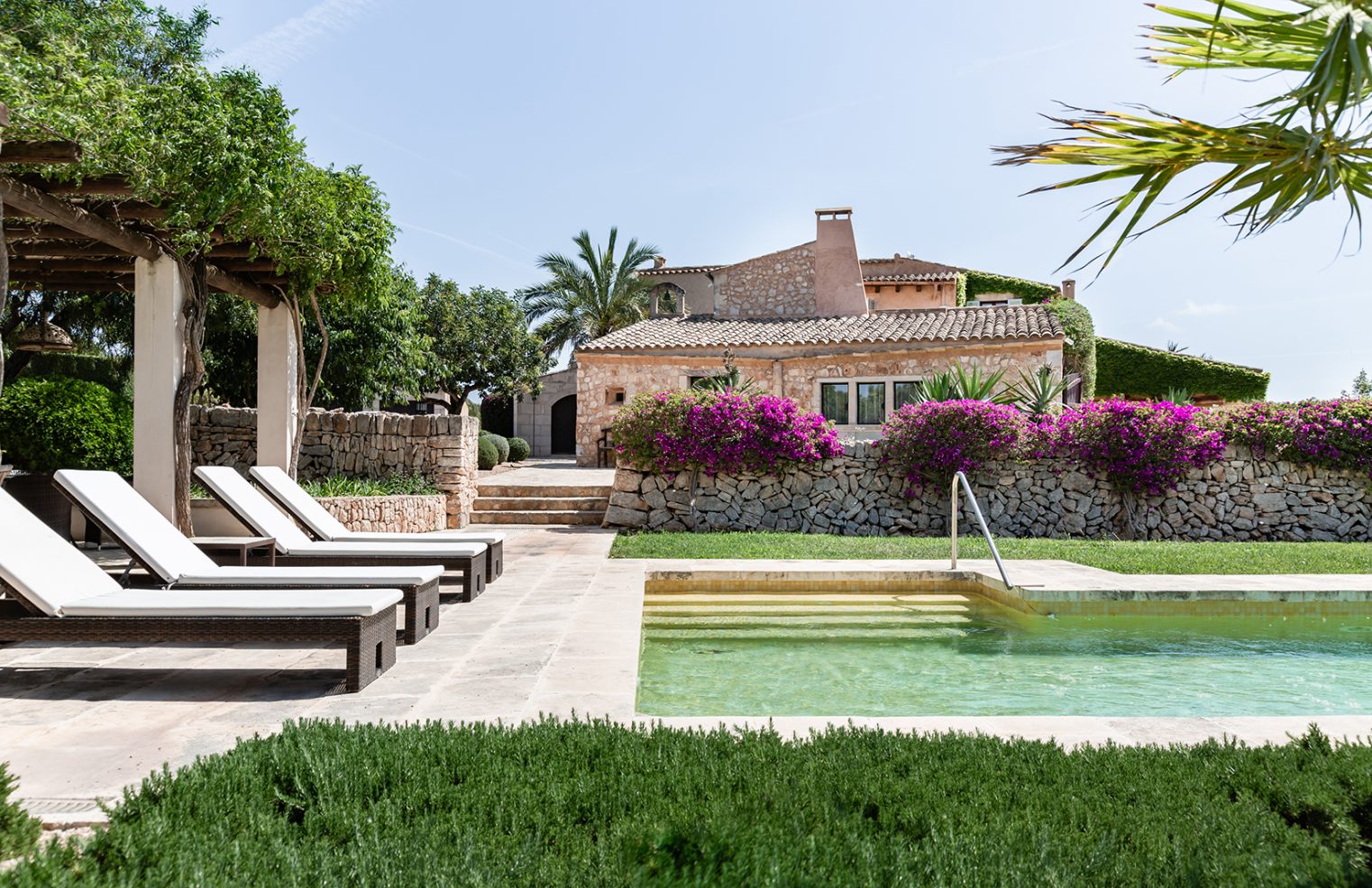 Lush gardens wrap around this rustic Mallorcan Finca in Santayi